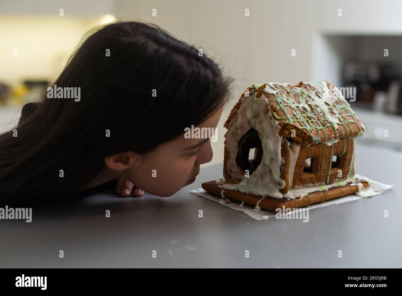 Kids with gingerbread house, A teenage girl is eating a gingerbread ...