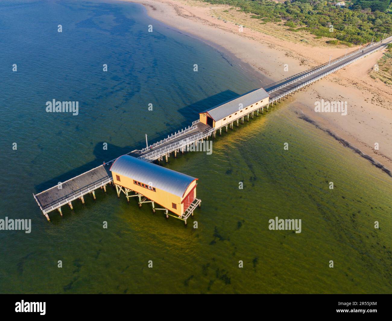 Aerial view of bout houses on a narrow pier over a quiet bay at ...