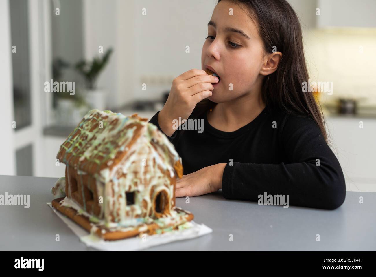 Kids with gingerbread house, A teenage girl is eating a gingerbread ...