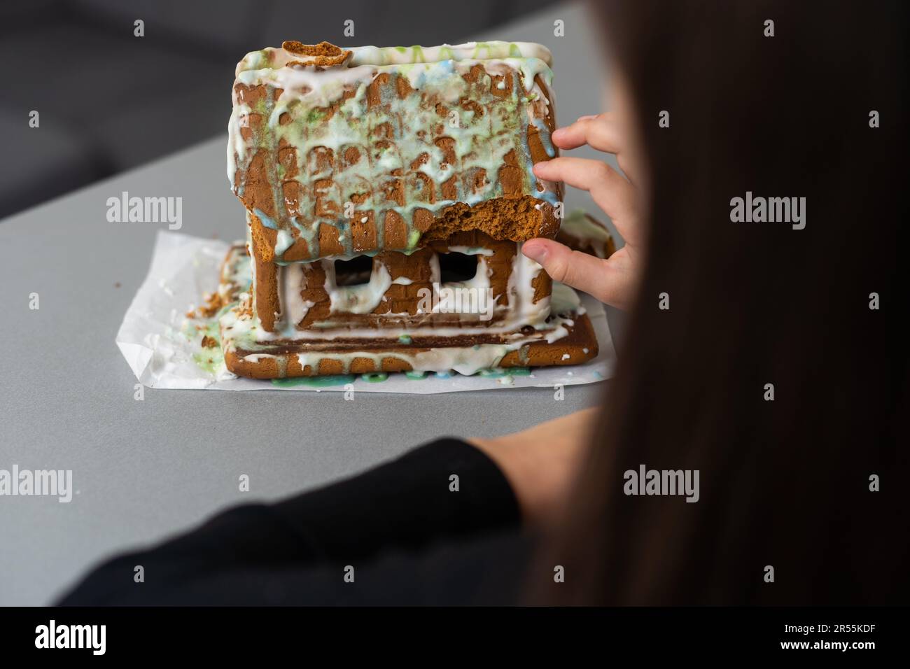 A teenage girl is eating a gingerbread house Stock Photo - Alamy