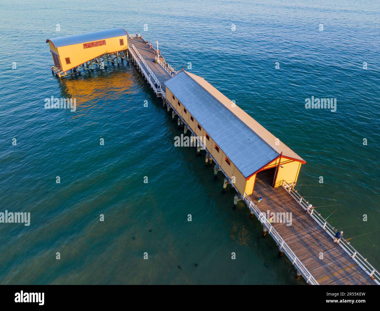 Aerial view of bout houses on a narrow pier over a quiet bay at ...