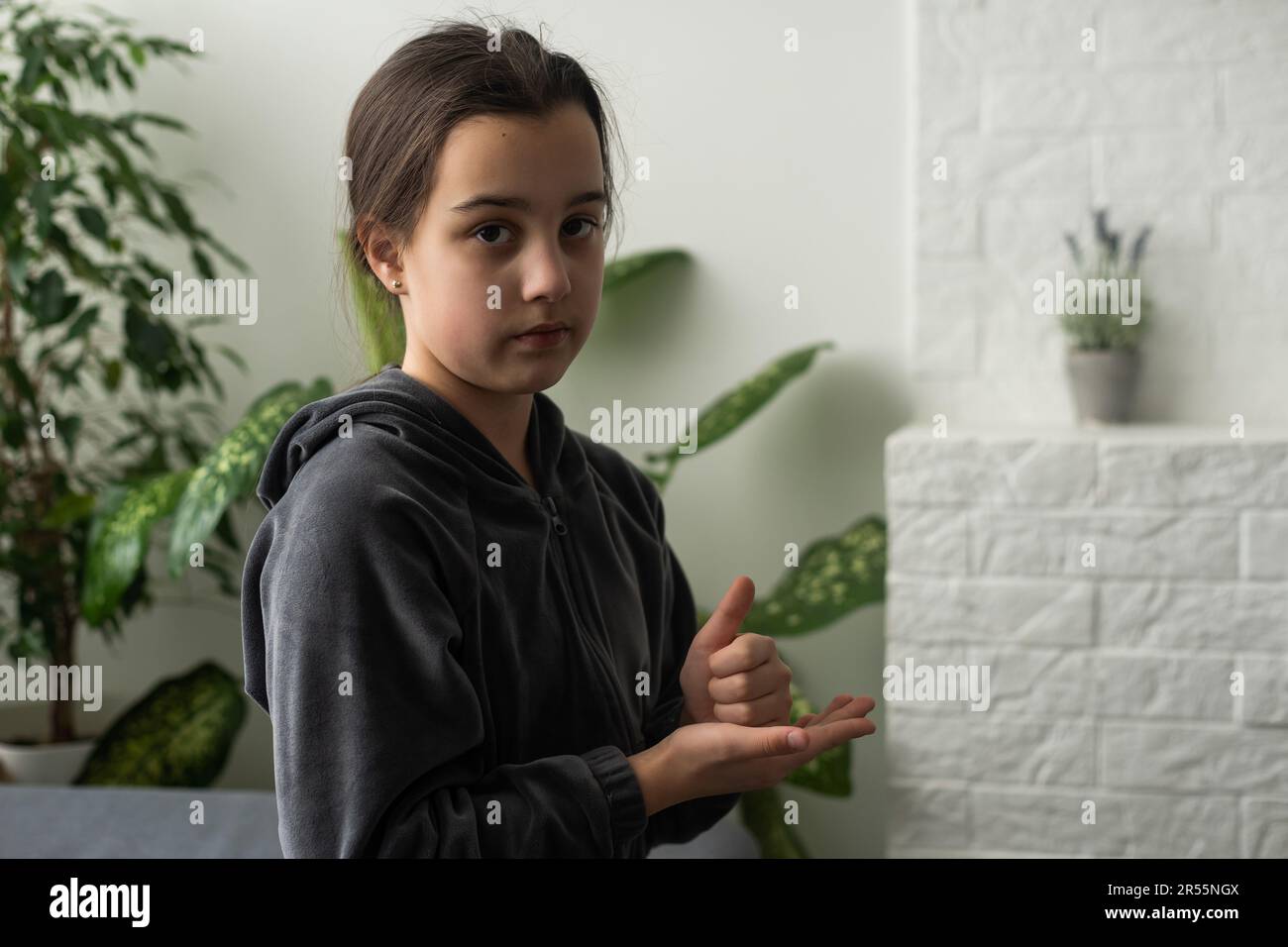 Cute deaf mute girl using sign language on light background Stock Photo ...
