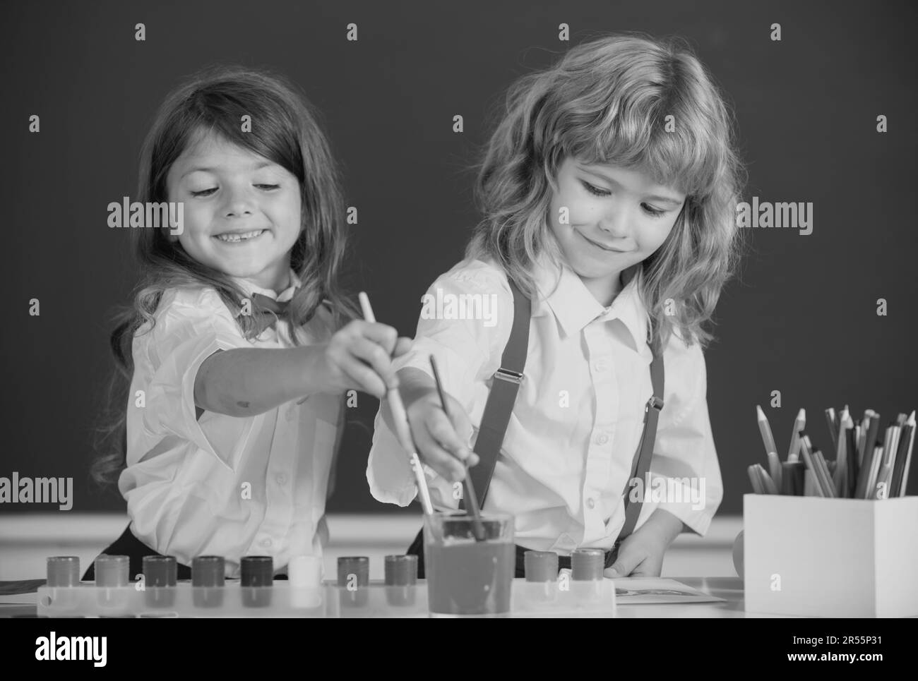 School children drawing a colorful pictures with pencil crayons in ...