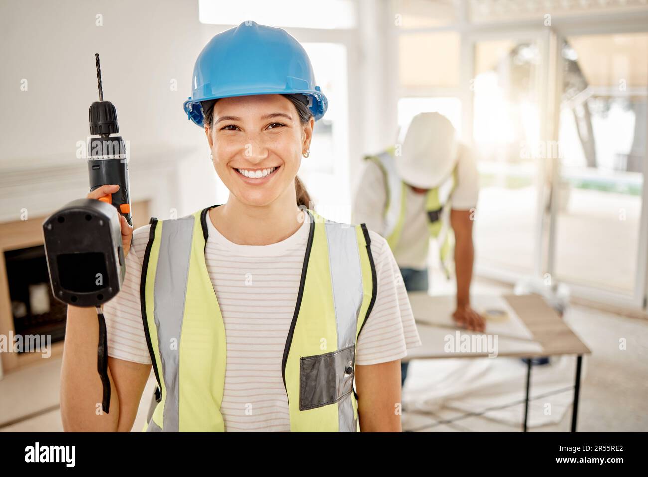 Portrait of woman, construction and home renovation with drill, helmet ...