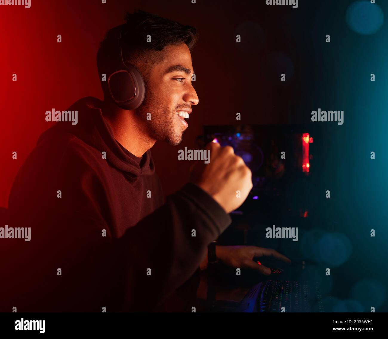 Man in dark room, video game and winning with fist pump, online ...