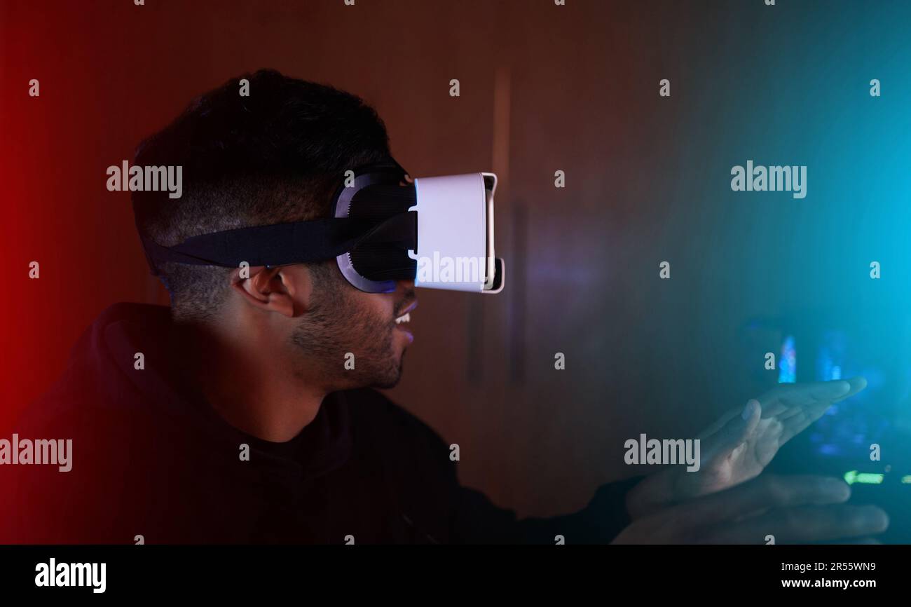 Man in dark room, video game and virtual reality, online streaming with ...