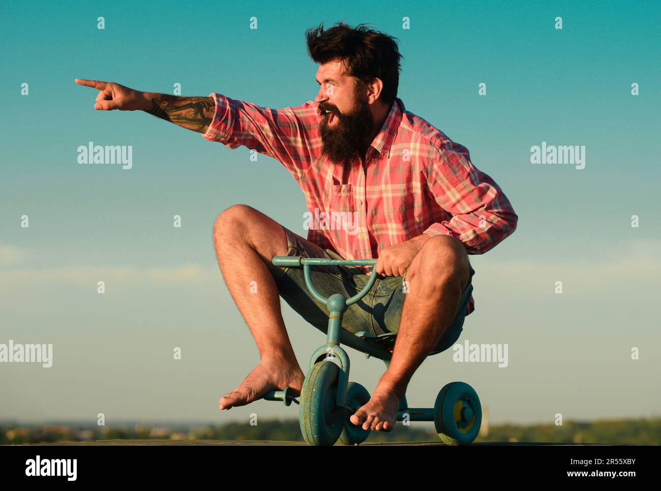 Crazy man riding a small bicycle. Excited young male riding a small ...