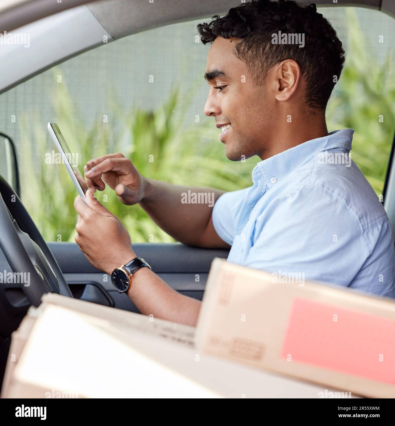 Courier, driver in car with tablet, smile and boxes, checking location ...