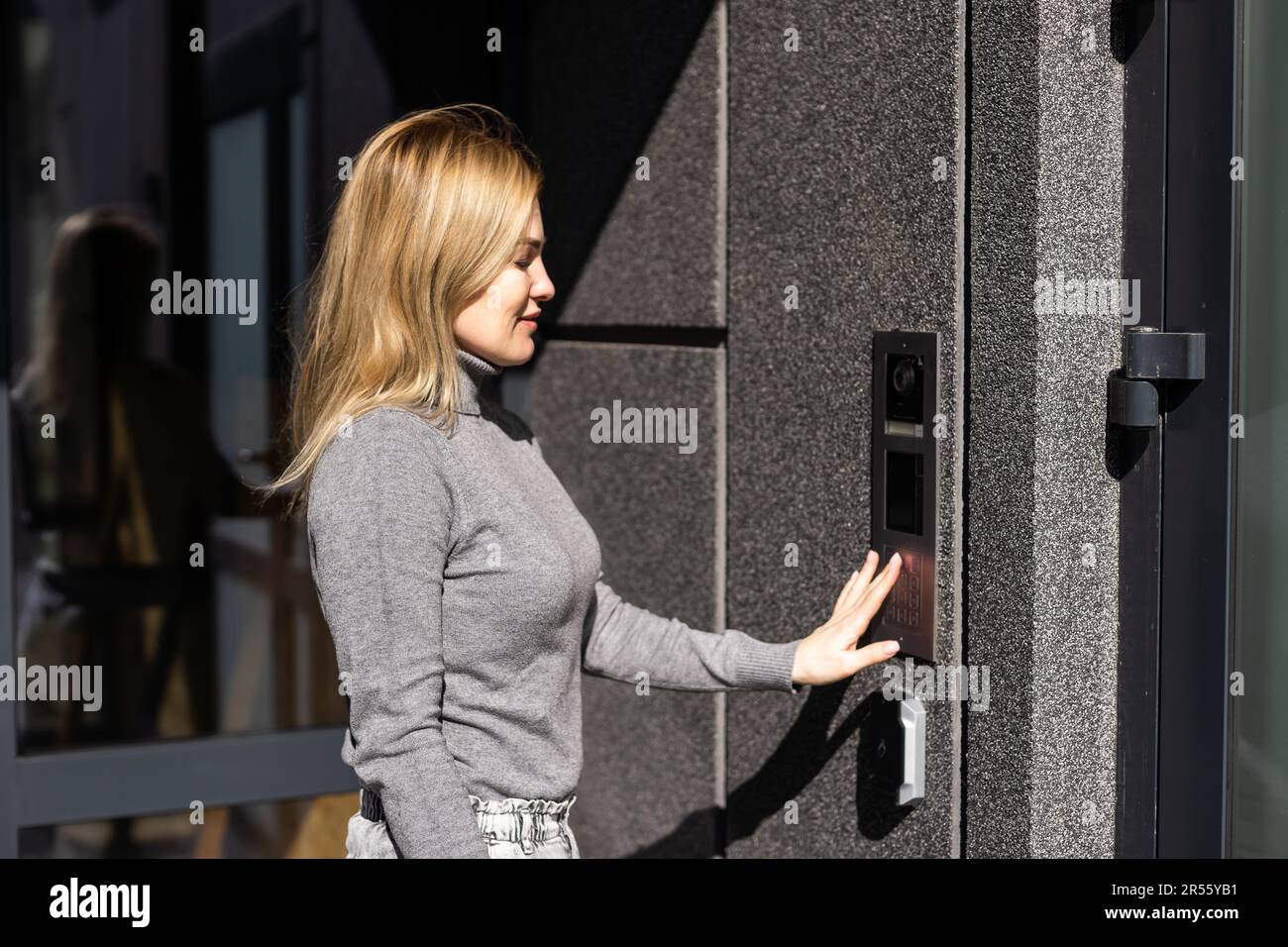 woman using intercom at building entrance Stock Photo - Alamy