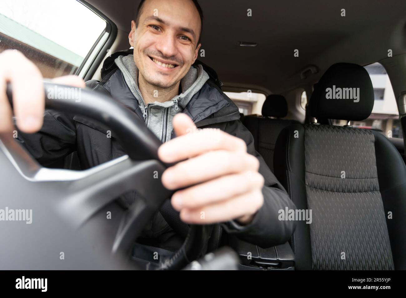 Joyful indian man driving car, shot from dashboard, going on trip ...