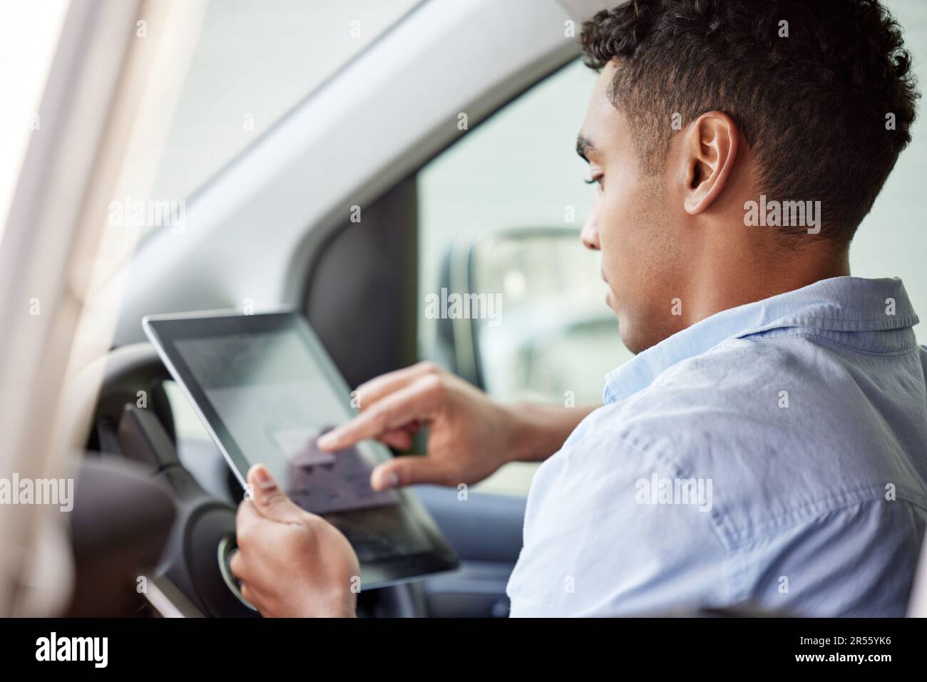 Tablet, navigation and a man driving a car while searching online for ...