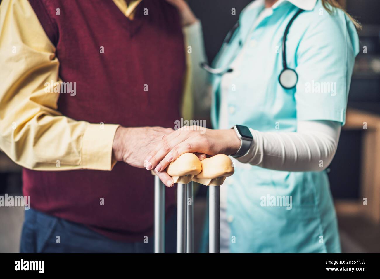 Nurse home caregiver is assisting old man at his home. Professional ...