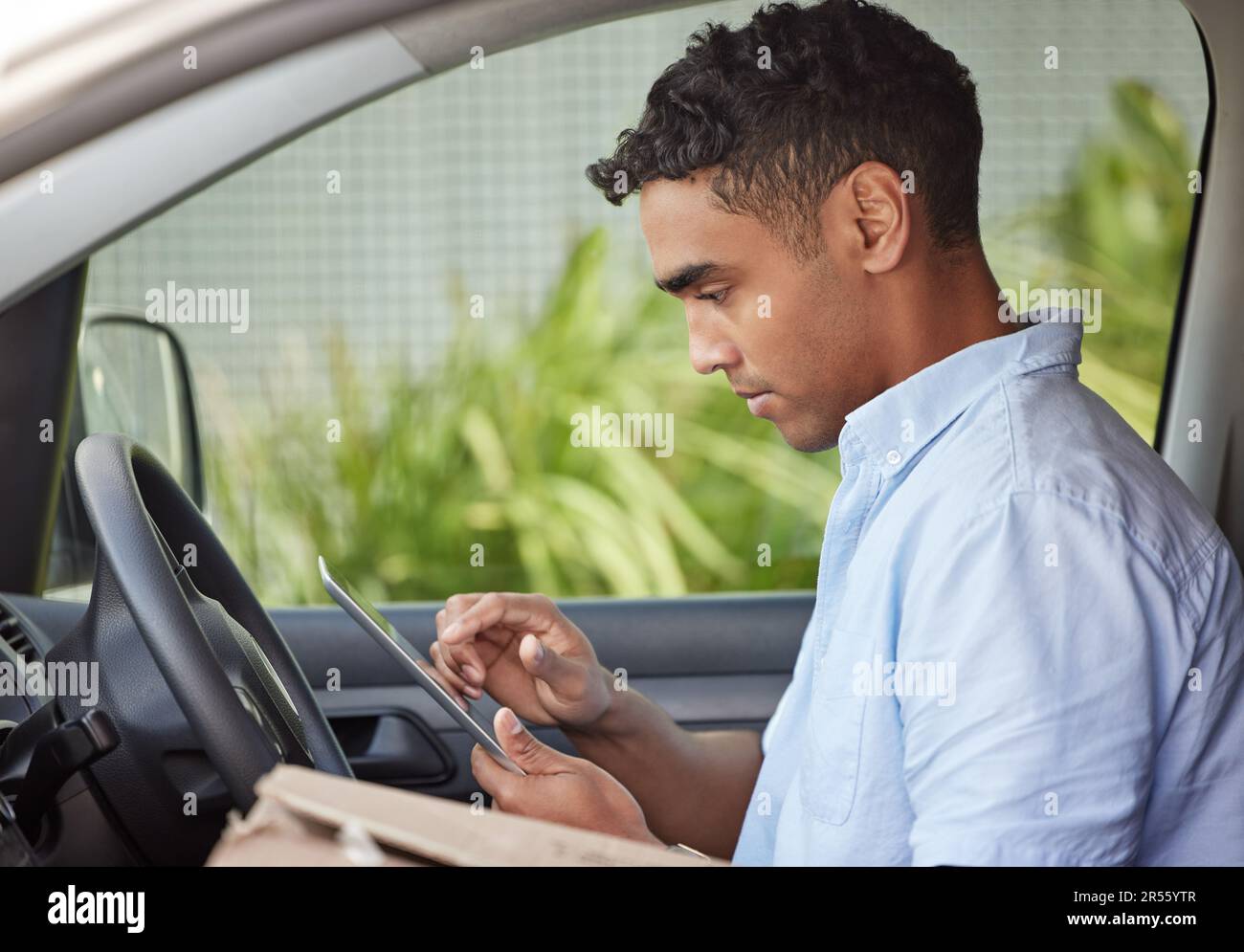 Delivery man in car with tablet, boxes and checking location, order ...