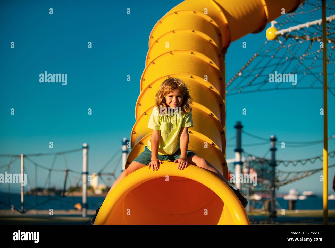 Funny cute kid playing in tunnel slide on playground Stock Photo - Alamy