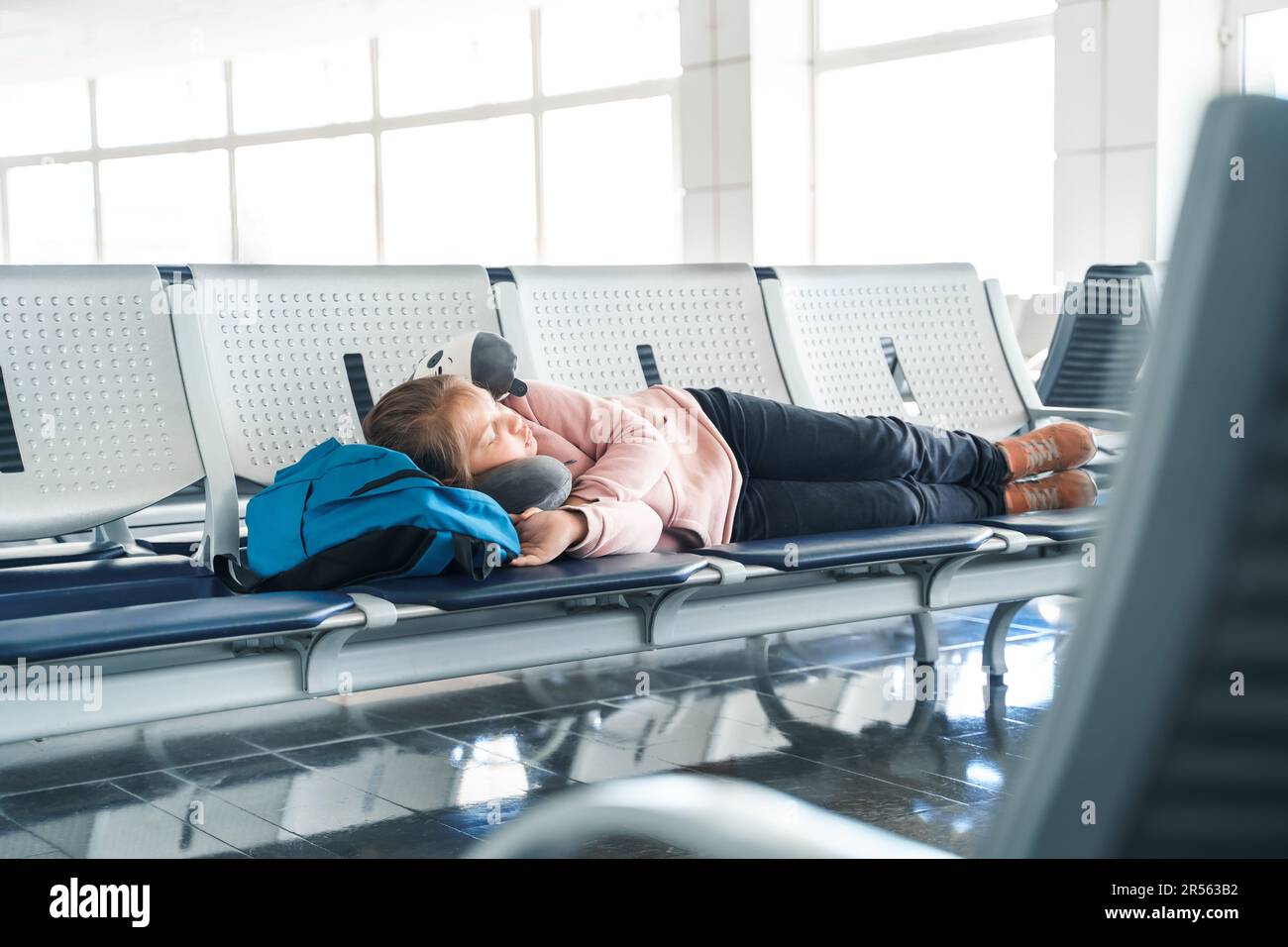 Kid, teen tired girl sleeping, waiting in airport passenger terminal ...