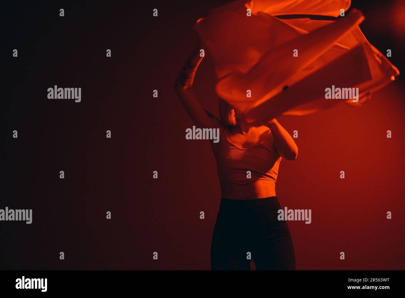 Female with jacket in raised arms in studio Stock Photo - Alamy