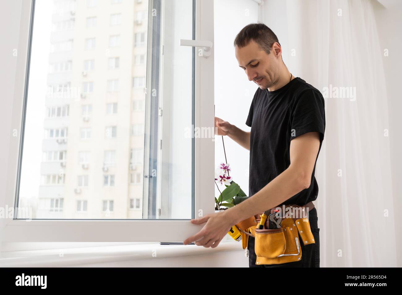 Construction worker installing window in house Stock Photo - Alamy