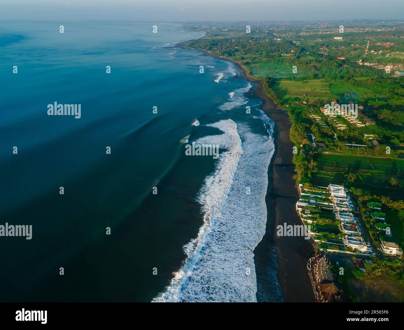 Aerial view of black sand coastline with ocean waves in Keramas, Bali ...