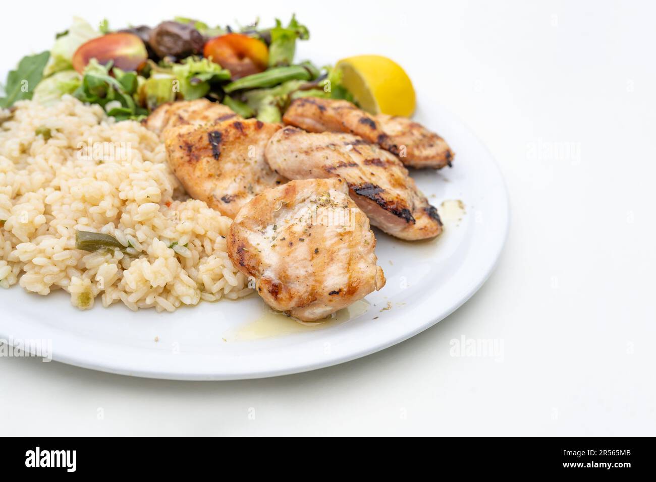 Roasted chicken fillet with rice, mixed salad and lemon, Mediterranean ...