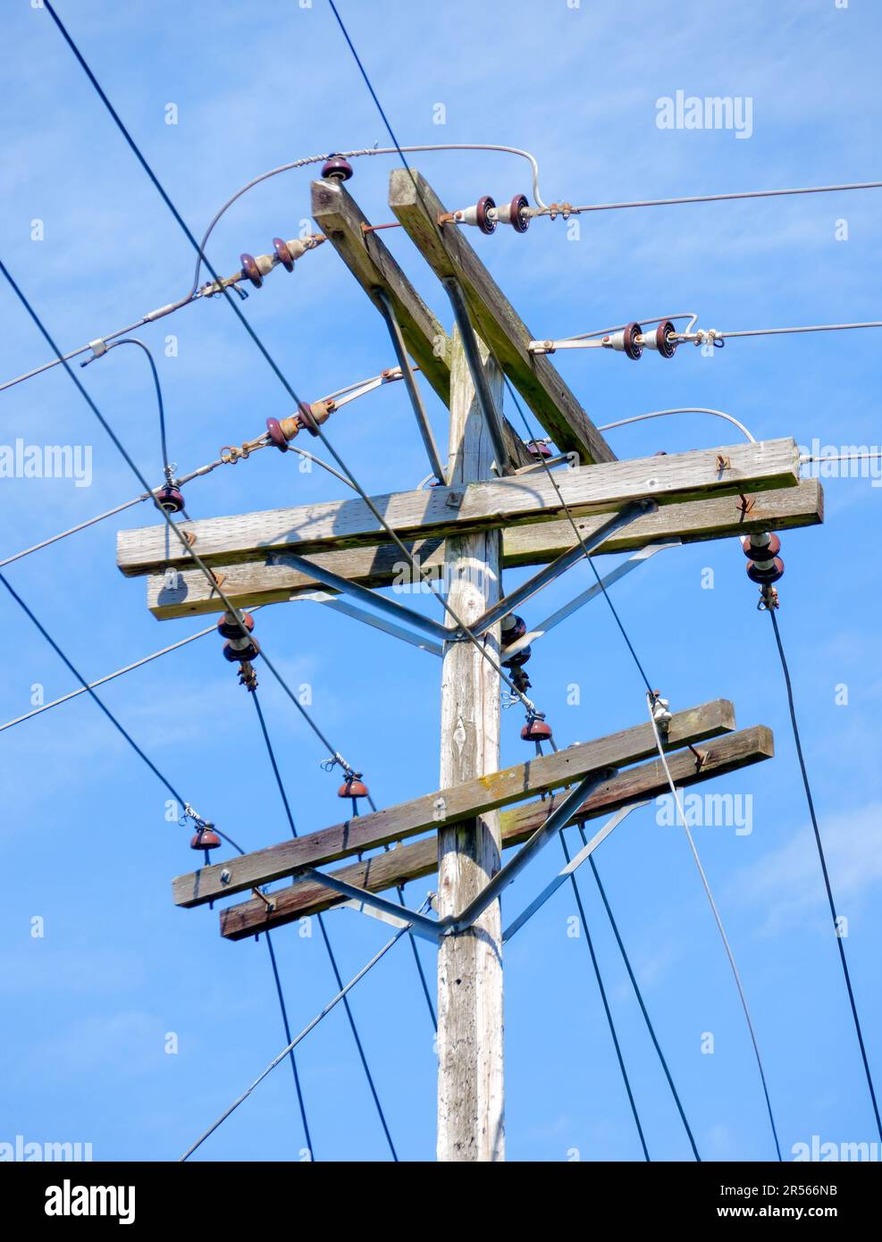 Electric pole and wires, wood electricty pole on blue sky background ...
