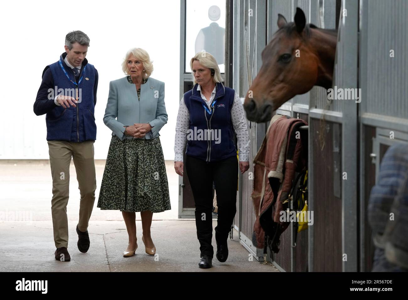 Britain's Queen Camilla walks with Chief Executive Andrew Braithwaite ...
