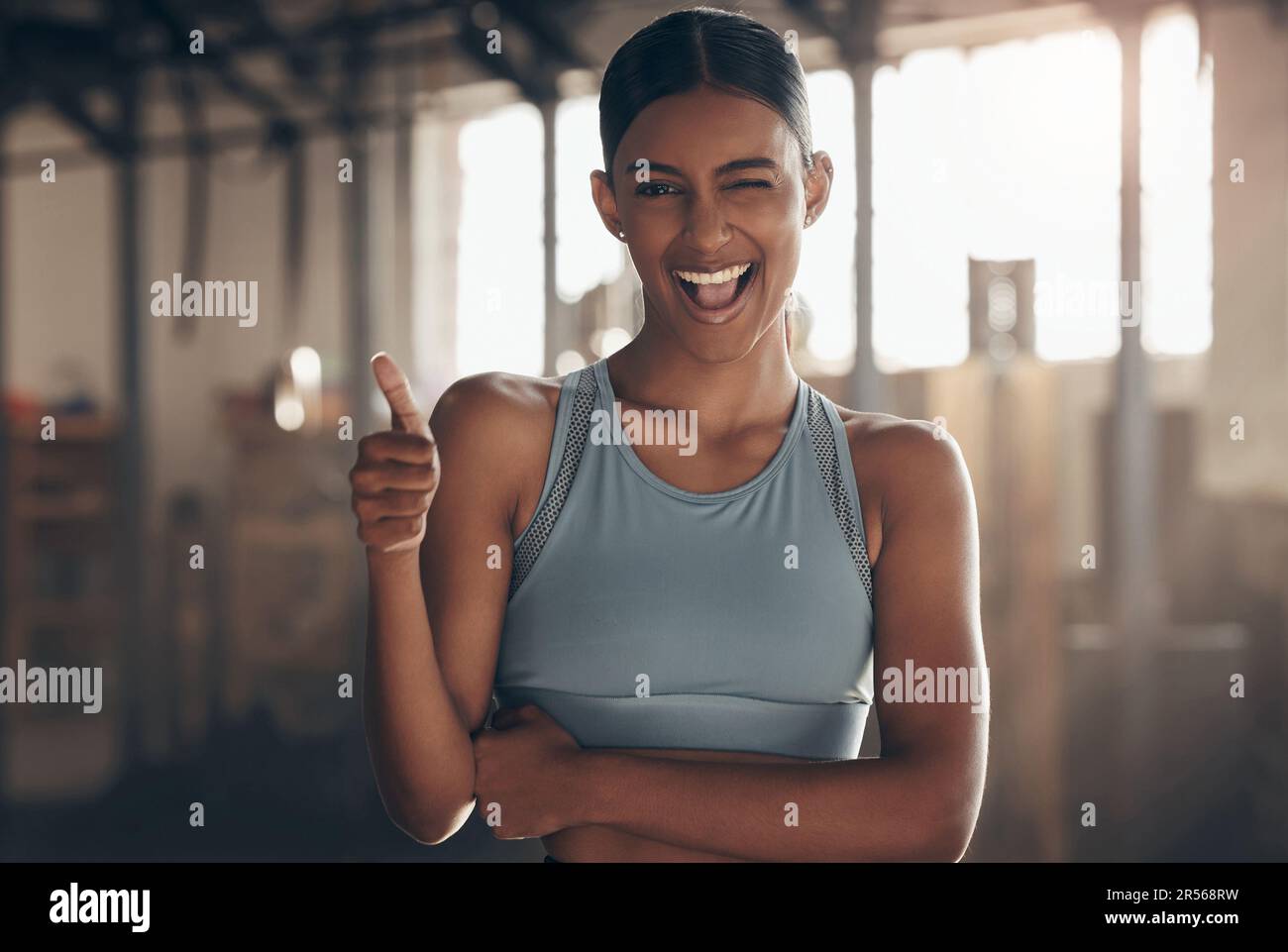 Woman in gym, thumbs up with wink in portrait, like fitness with emoji ...