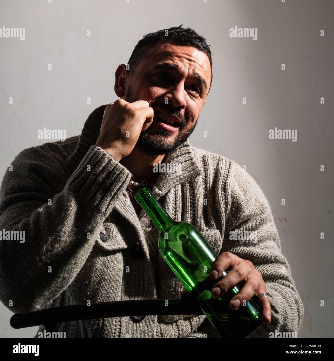 He is binge drinking. Hispanic man suffering from unhealthy alcohol drinking dependance ...