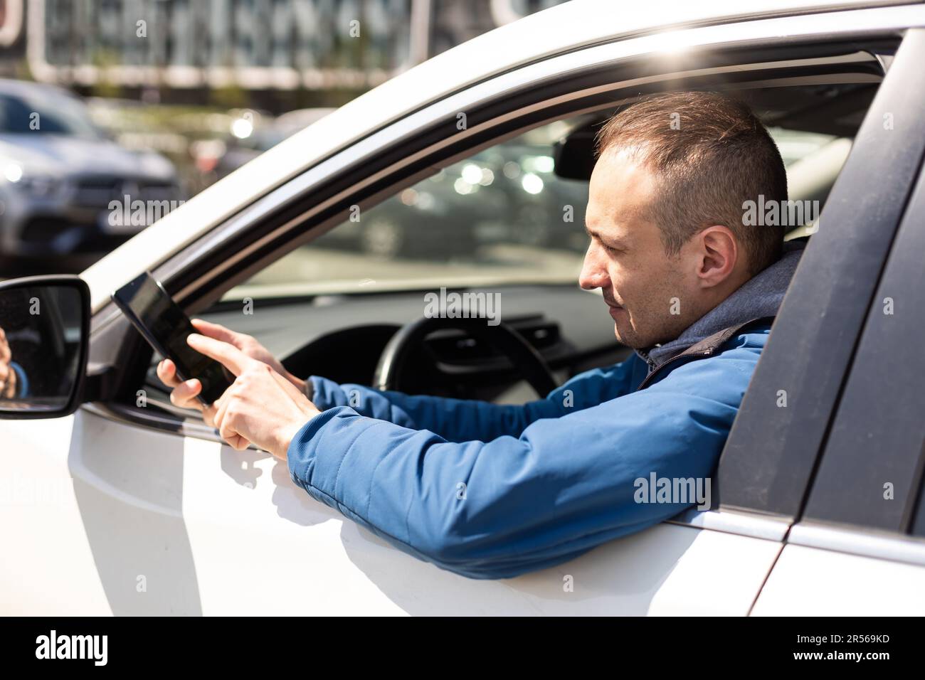 Smartphone man in car driving showing smart phone display smiling happy ...