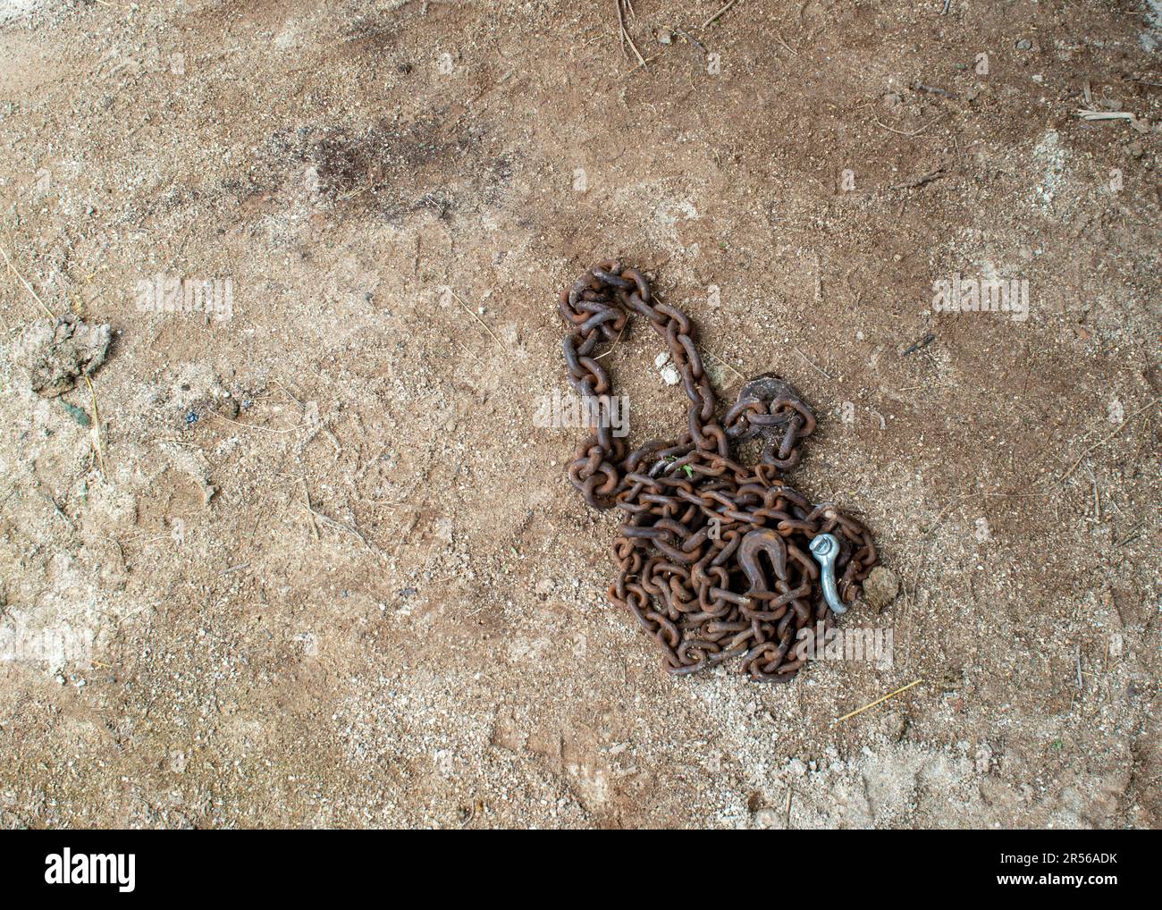 An old rusty log chain has been left on the dry parched brown ground ...