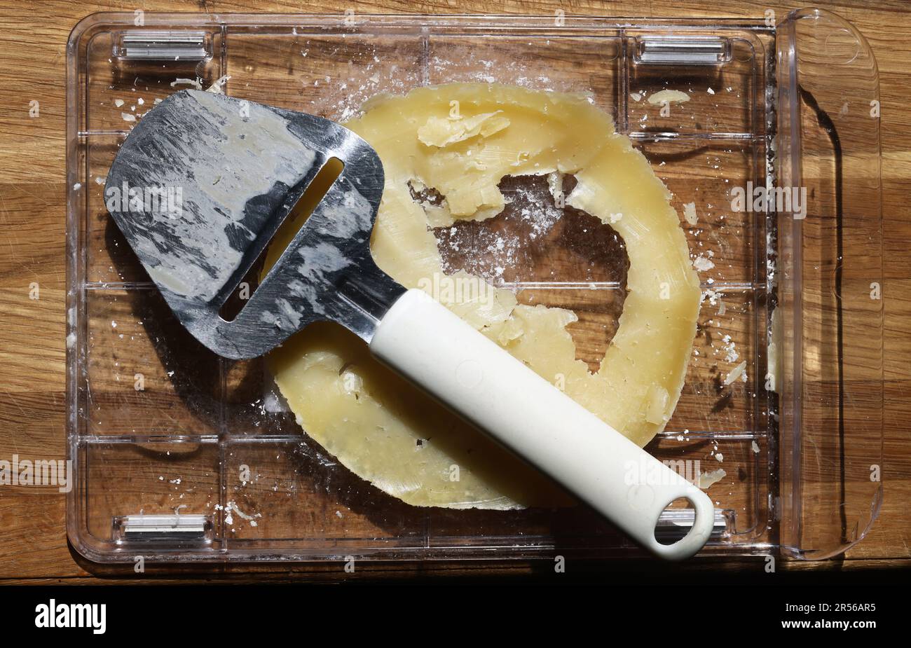 A cheese that starts to end and a cheese slicer that needs to be washed ...