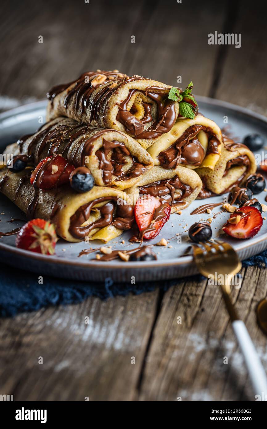 Crepes with chocolate filling arranged in pyramid shape with seasonal ...