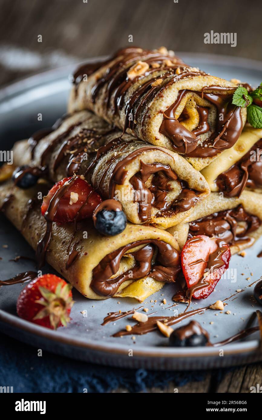 Crepes with chocolate filling arranged in pyramid shape with seasonal ...