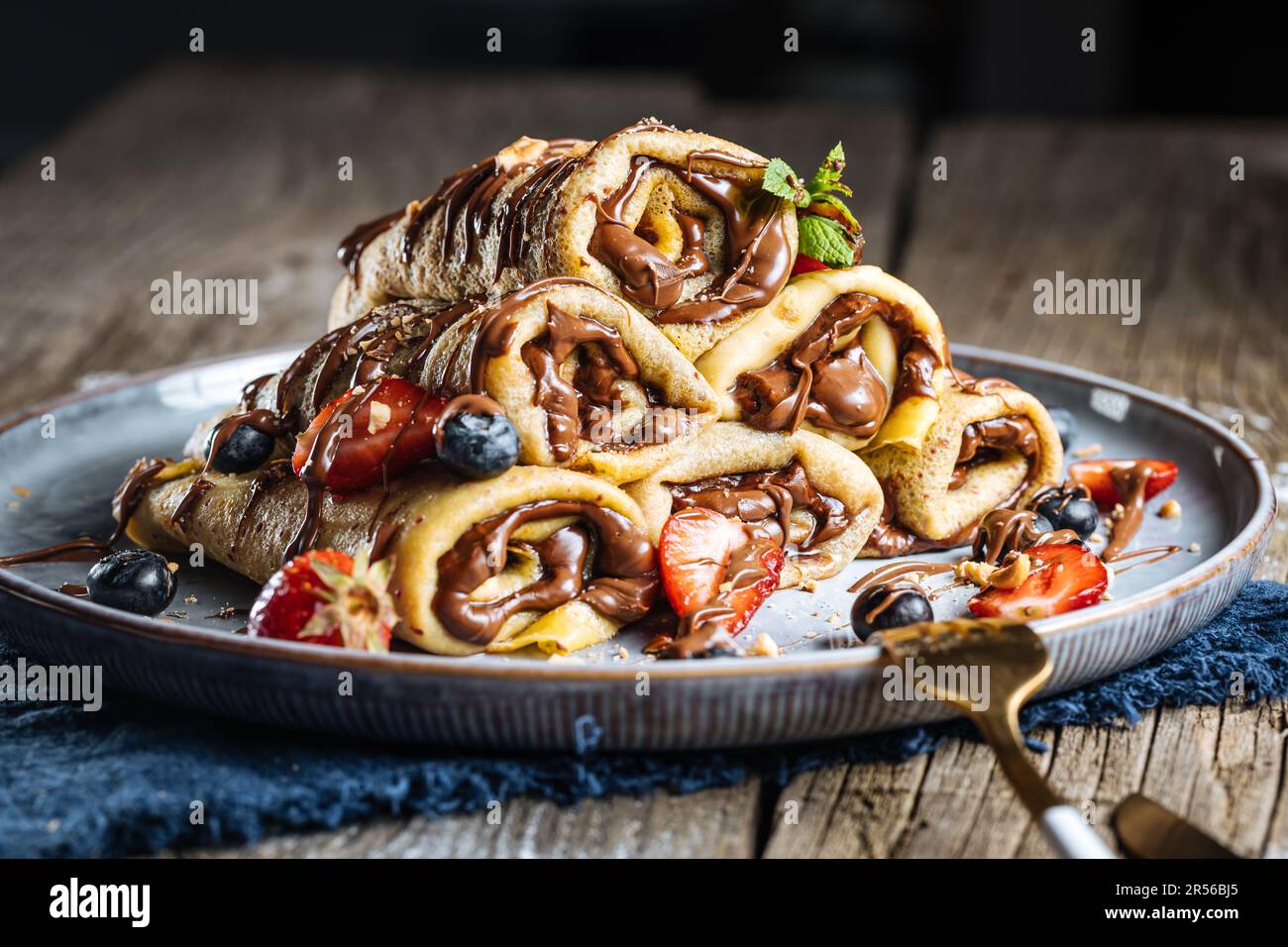 Crepes with chocolate filling arranged in pyramid shape with seasonal ...