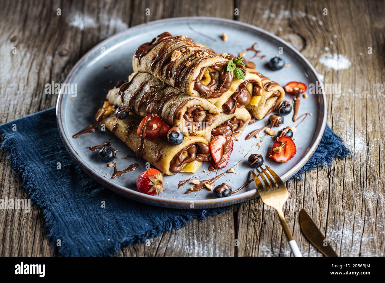 Crepes with chocolate filling arranged in pyramid shape with seasonal ...