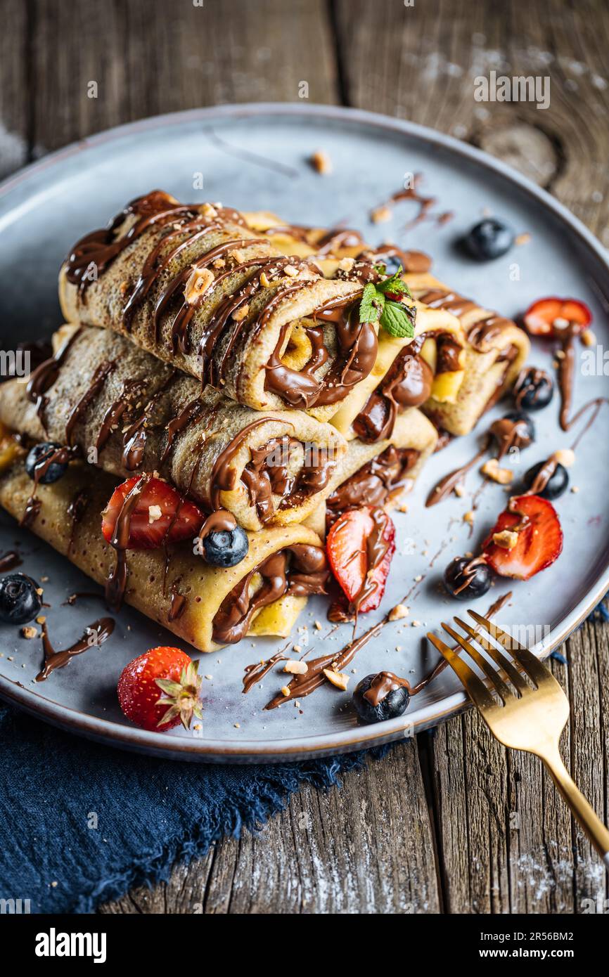 Crepes with chocolate filling arranged in pyramid shape with seasonal ...