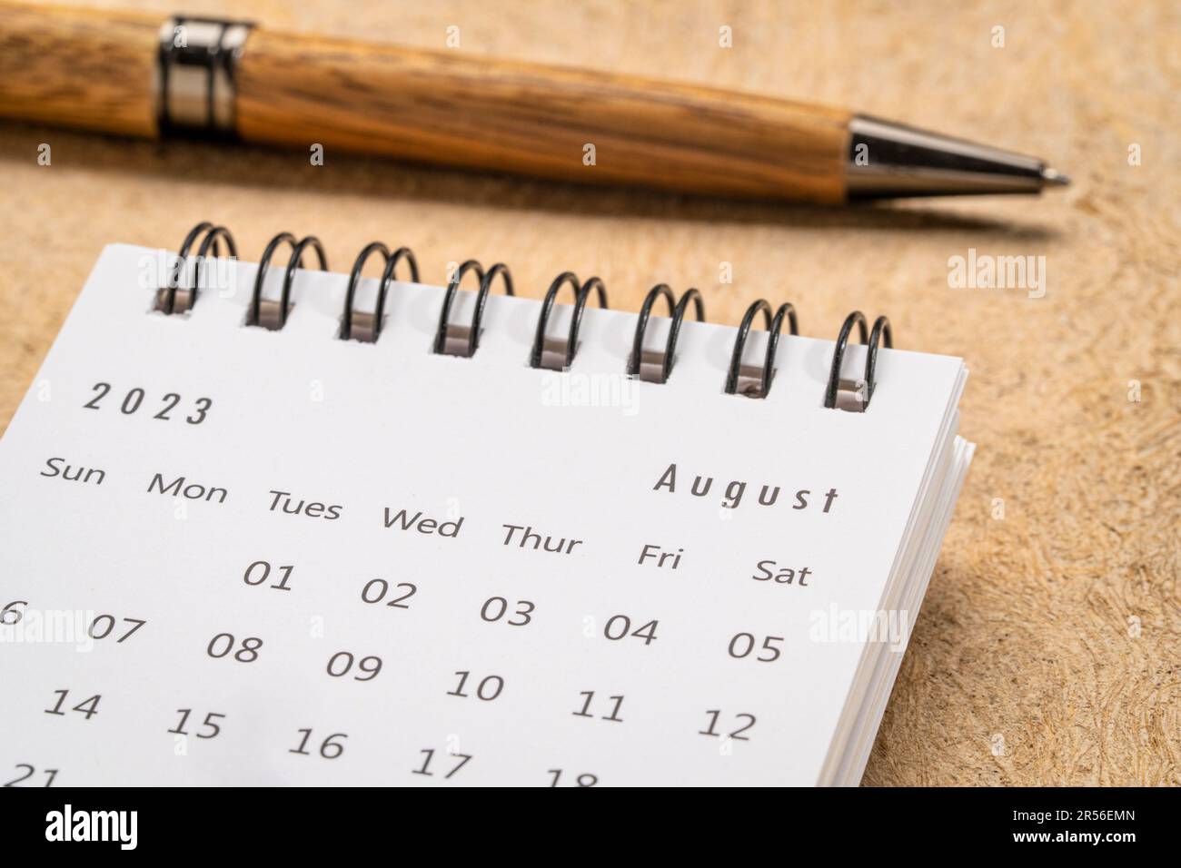 August 2023 - closeup of a small desktop calendar with a pen, time and ...