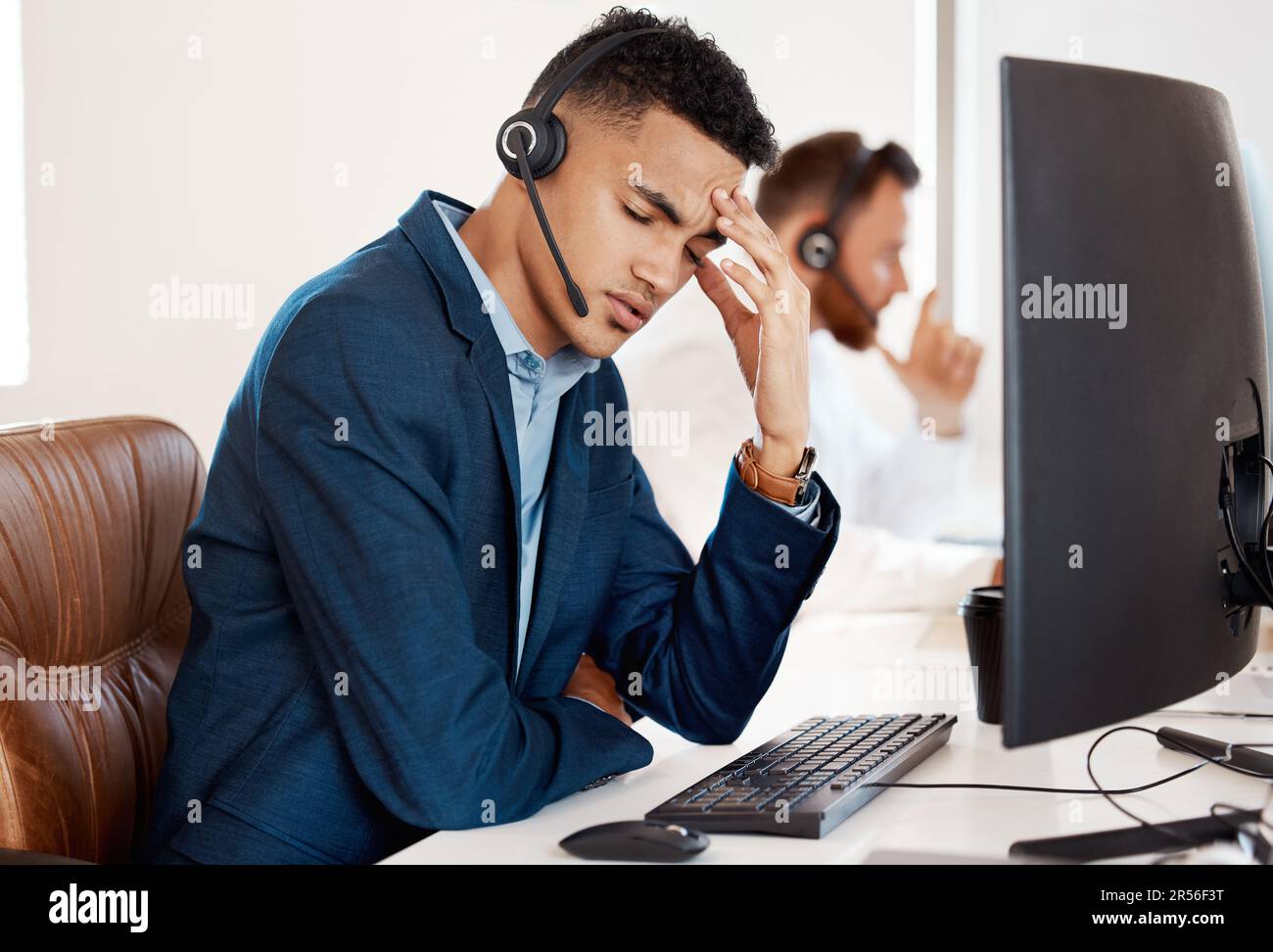 Mental health, man with headache and headset with computer at his desk ...