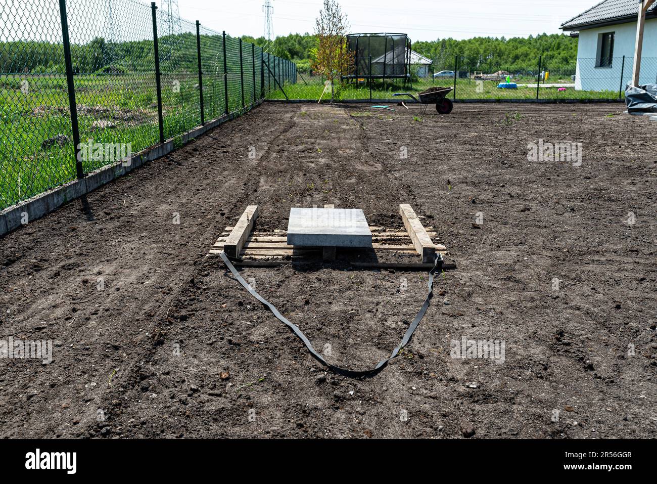 Leveling the chernozem in the yard with a pallet weighted with a ...