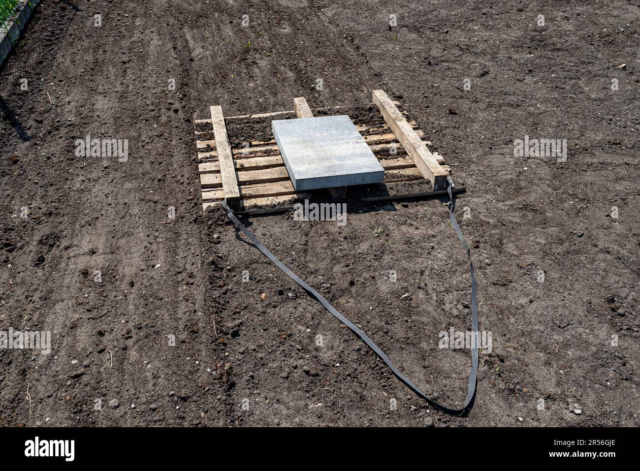 Leveling the chernozem in the yard with a pallet weighted with a ...