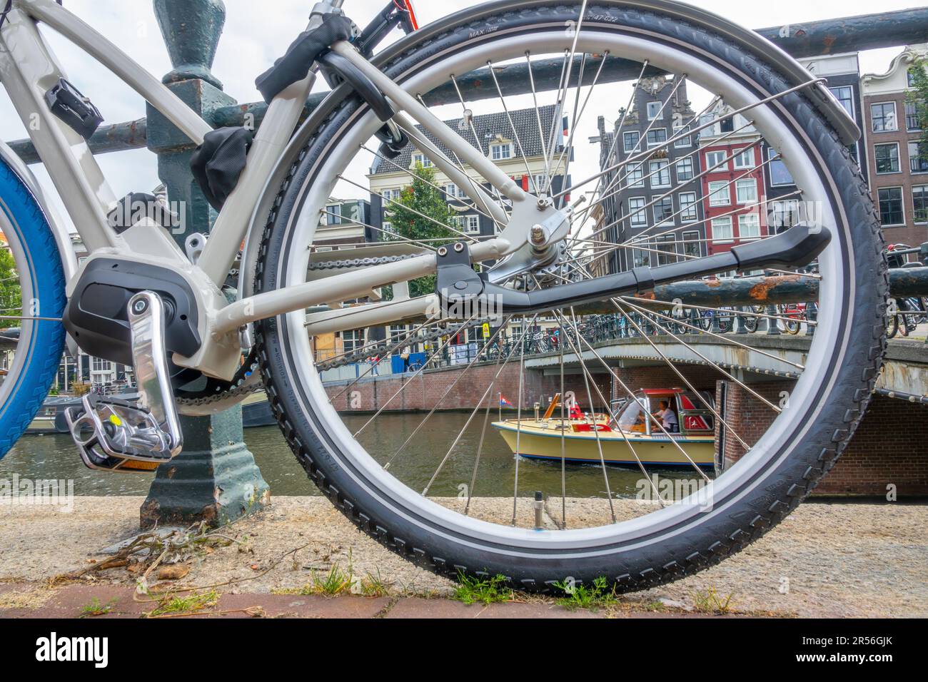 Netherlands. Summer day on the Amsterdam canal. Big bicycle wheel and ...