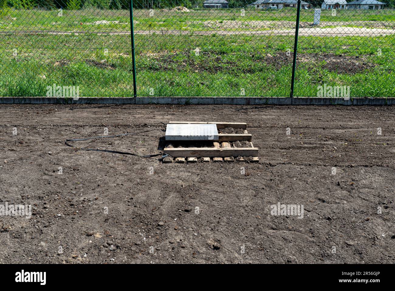 Leveling the chernozem in the yard with a pallet weighted with a ...