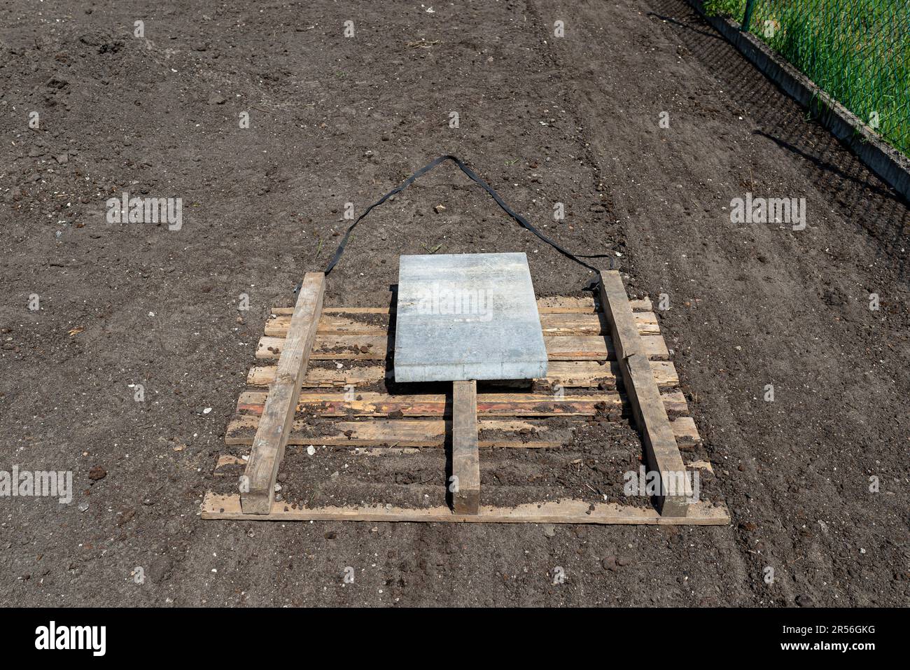 Leveling the chernozem in the yard with a pallet weighted with a ...