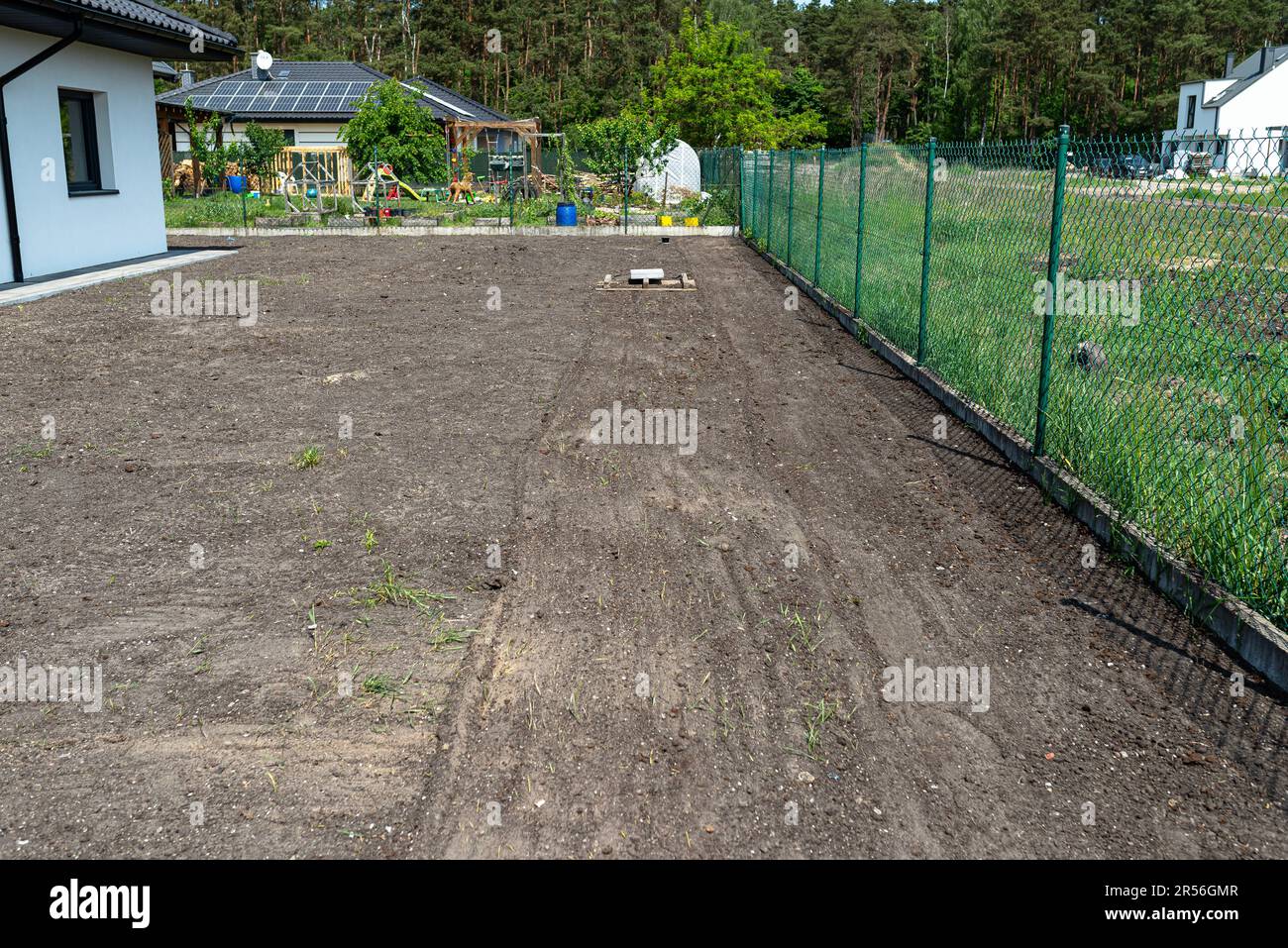 Leveling the chernozem in the yard with a pallet weighted with a ...