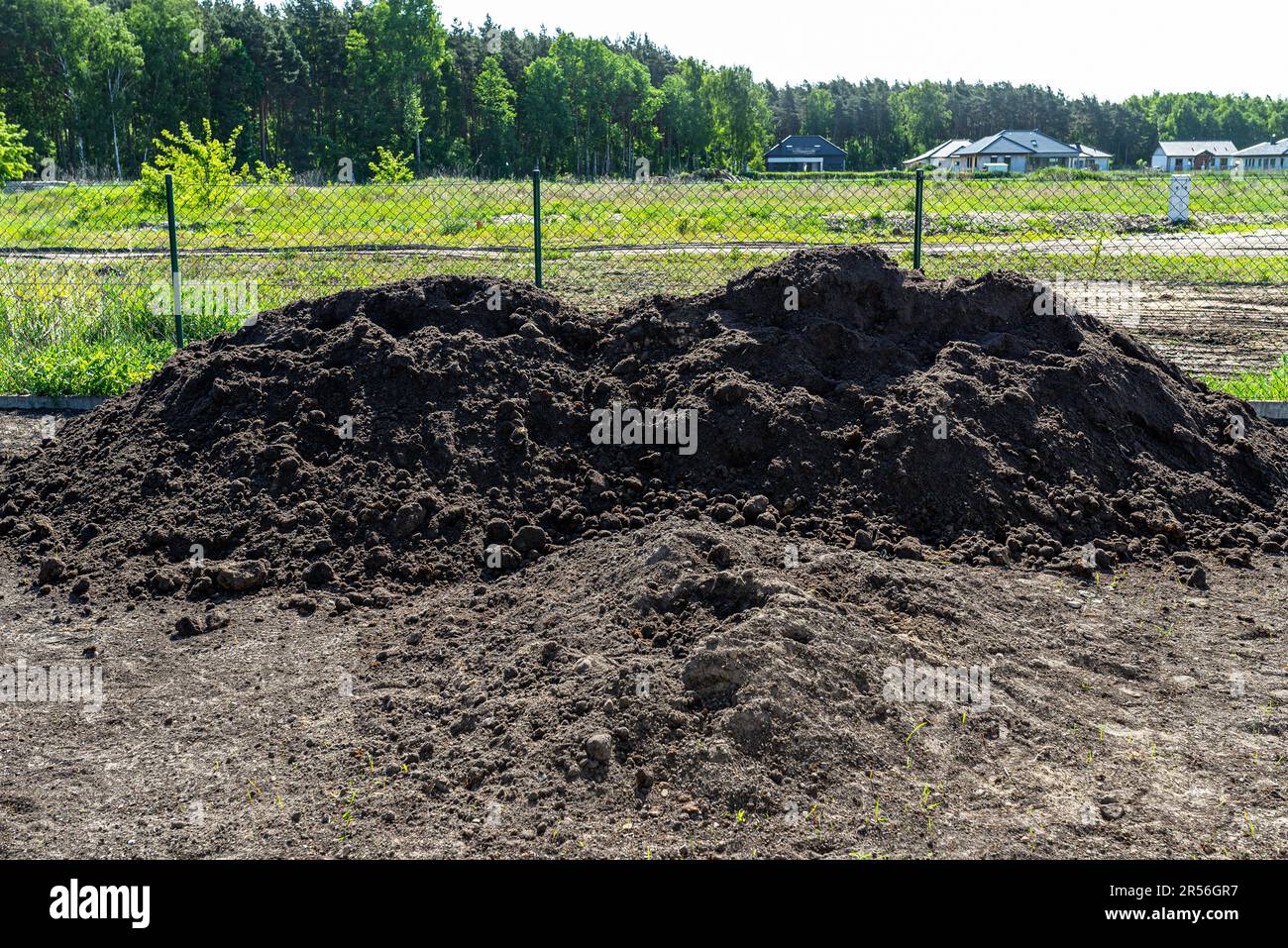 A heap of pure black earth lying in the yard next to the fence Stock ...