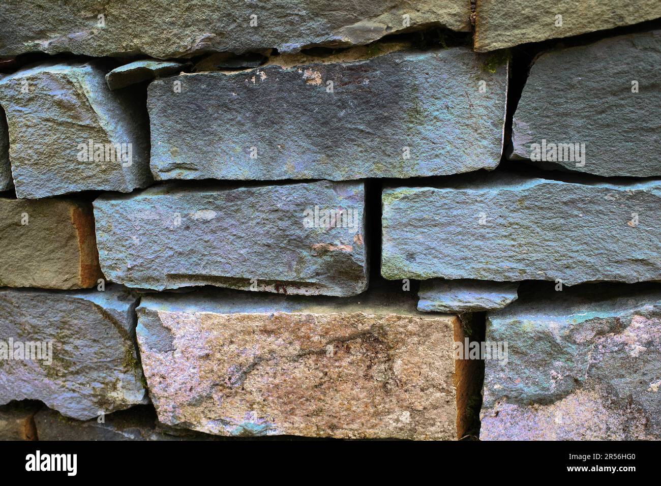An old dry stone slate garden wall. The stones are stacked. The color ...