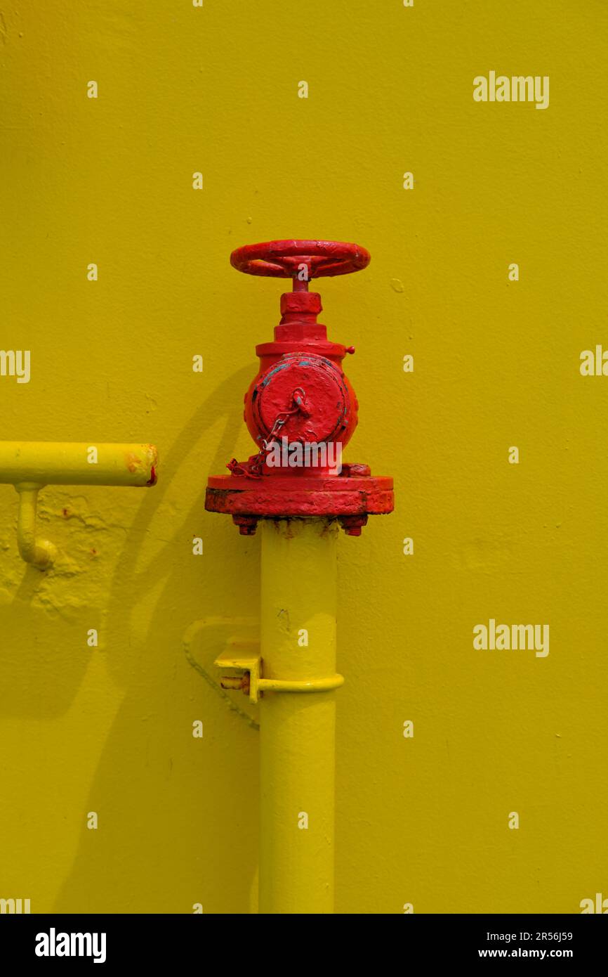 A red painted fire hydrant valve with a wheel for shutting and opening ...