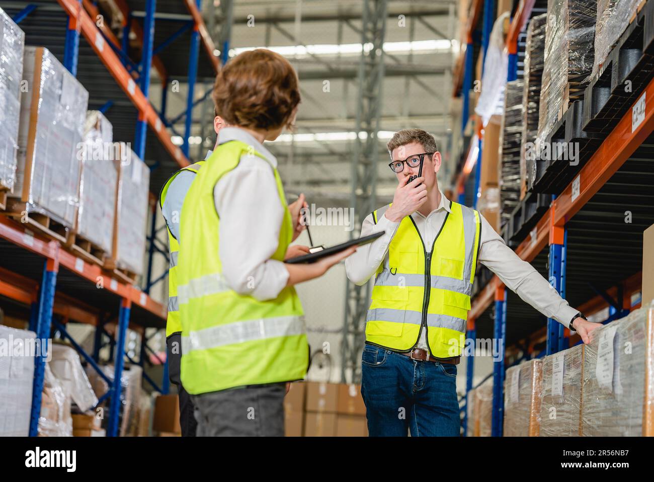 Warehouse workers talking together checking goods in storage Stock ...