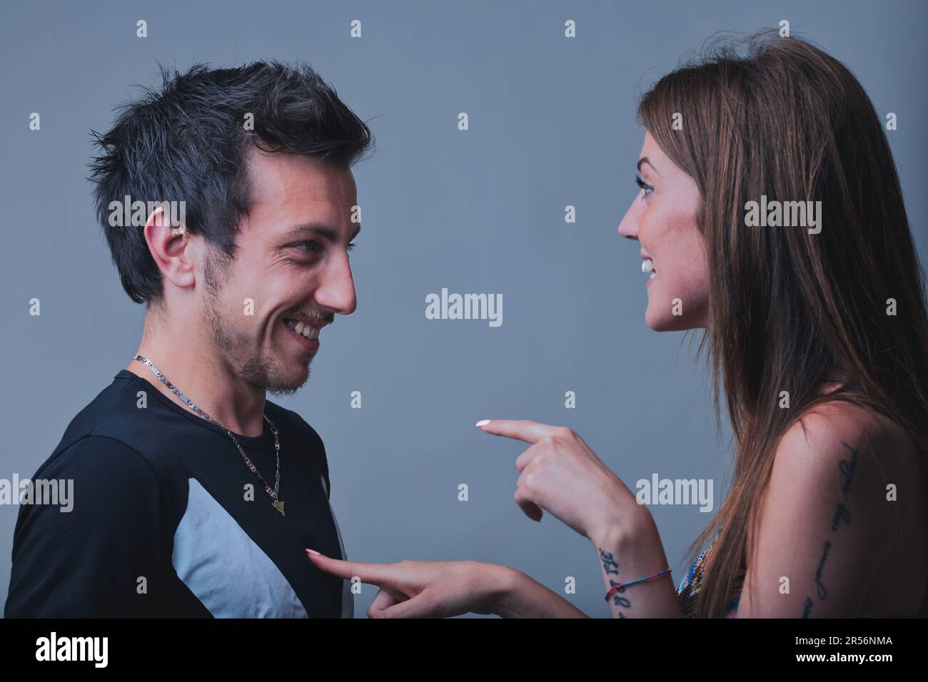 Playful taps on her boyfriend's chest, a young woman's childlike ...