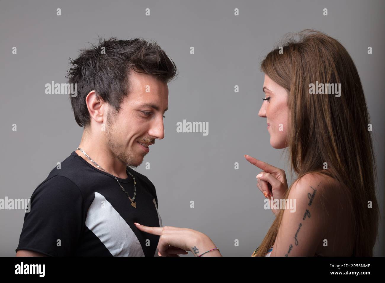 Playful taps on her boyfriend's chest, a young woman's childlike ...