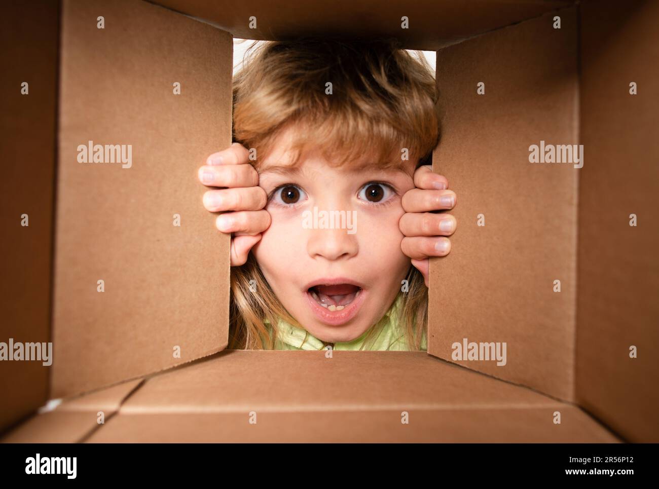 Unpacking cardboard box for kids. Cheerful cute child opening a present ...